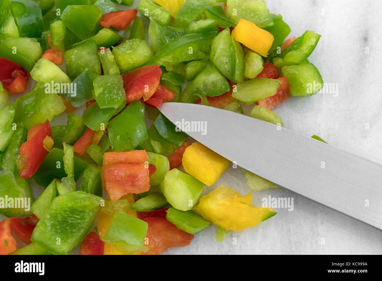 A small portion of chopped red, yellow and green bell peppers with a ...