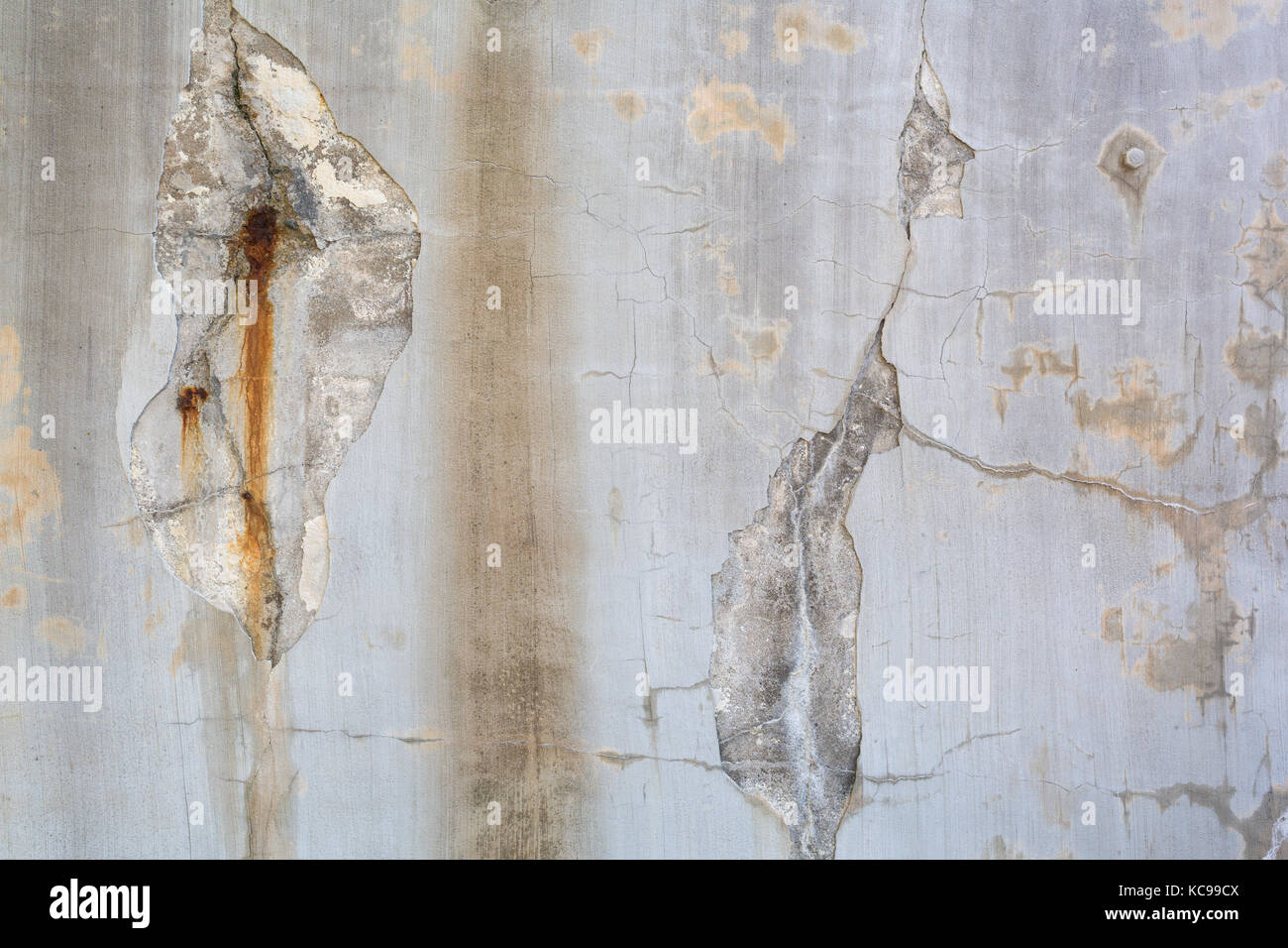 Concrete retaining wall that is damaged with rebar rust showing in the ...