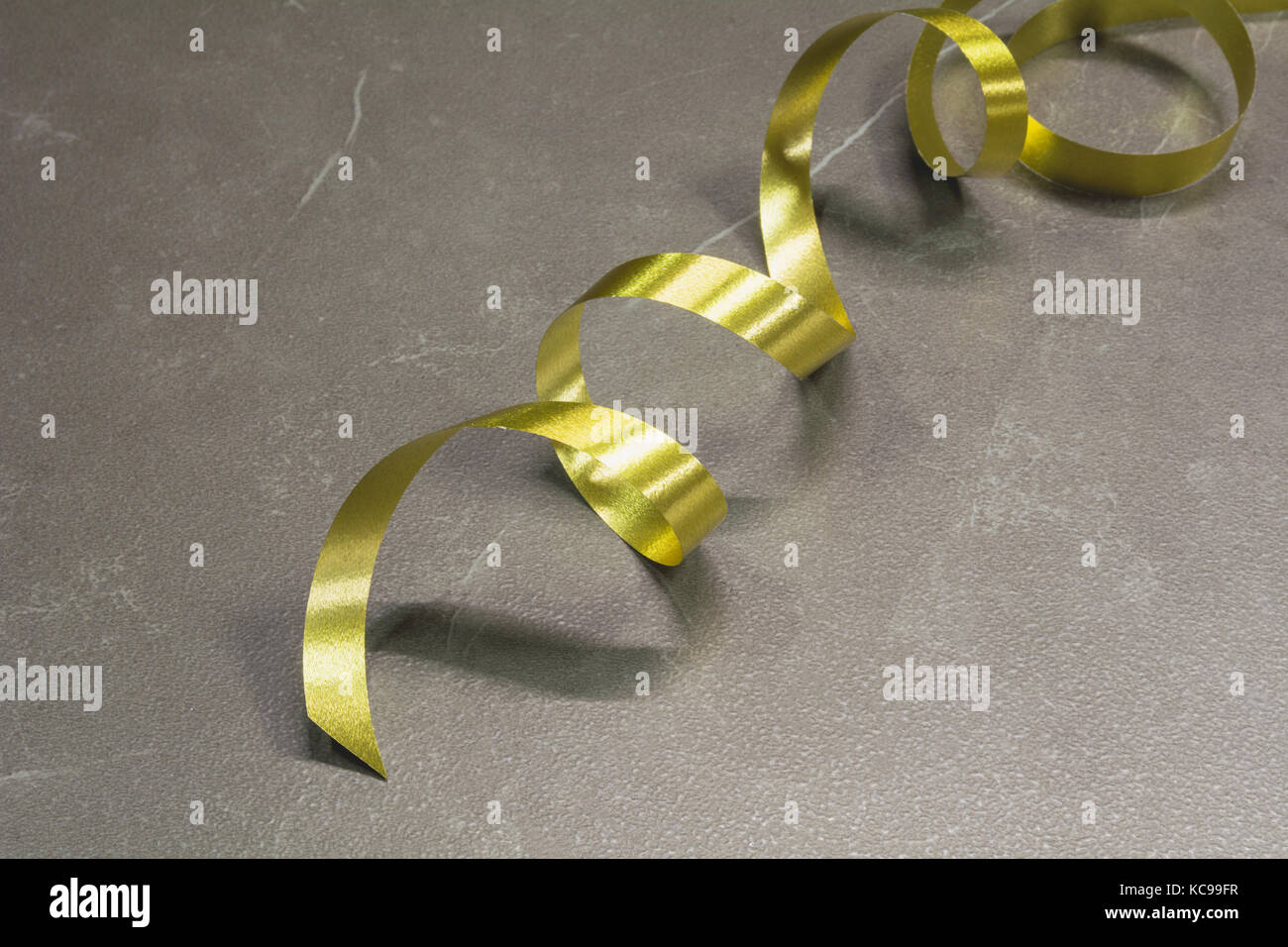 The spiral golden ribbon on leather table background Stock Photo - Alamy