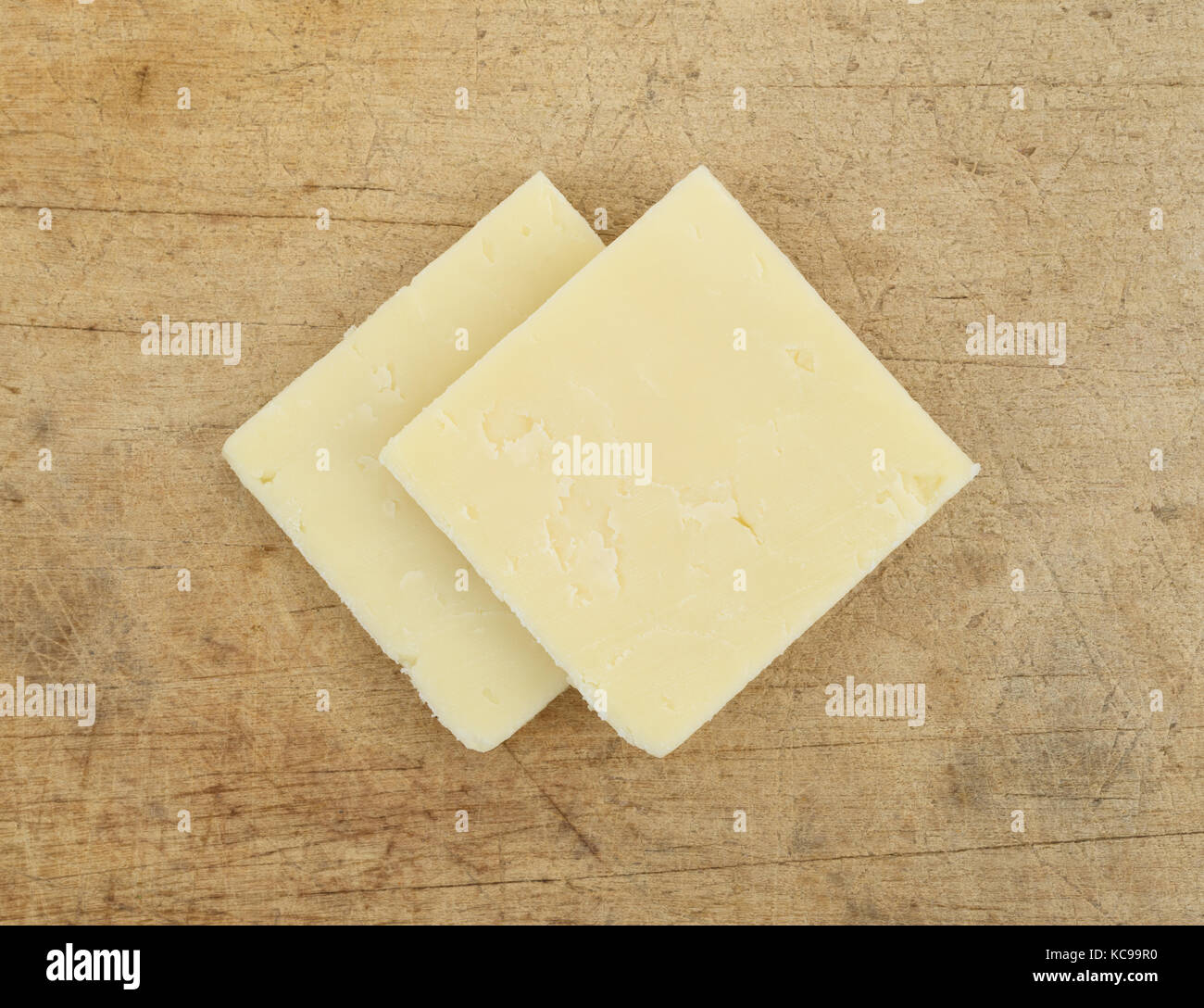 Top close view of two slices of sharp cheddar cheese squares on an old ...