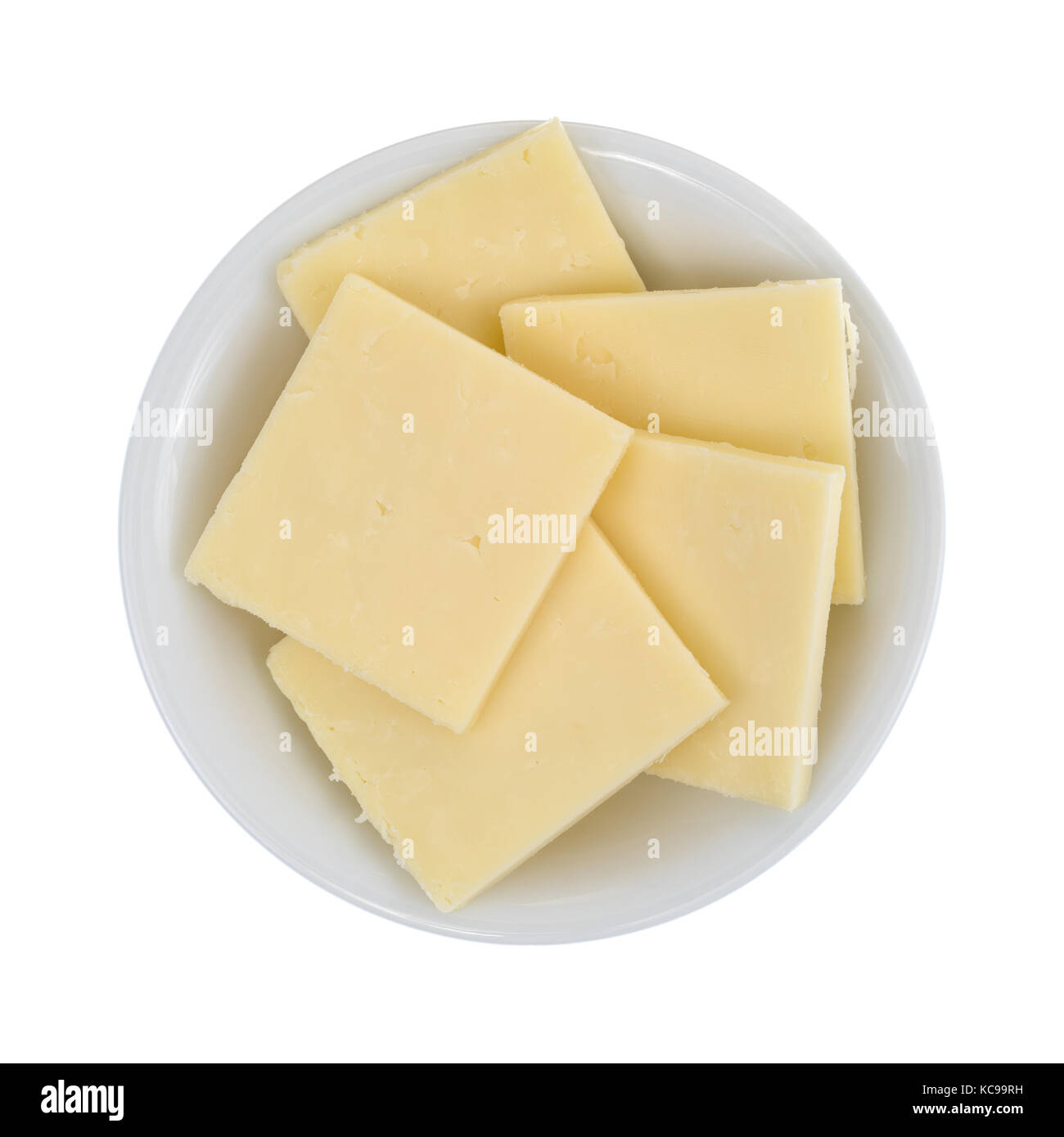 Top view of a small bowl filled with sharp cheddar cheese square slices ...
