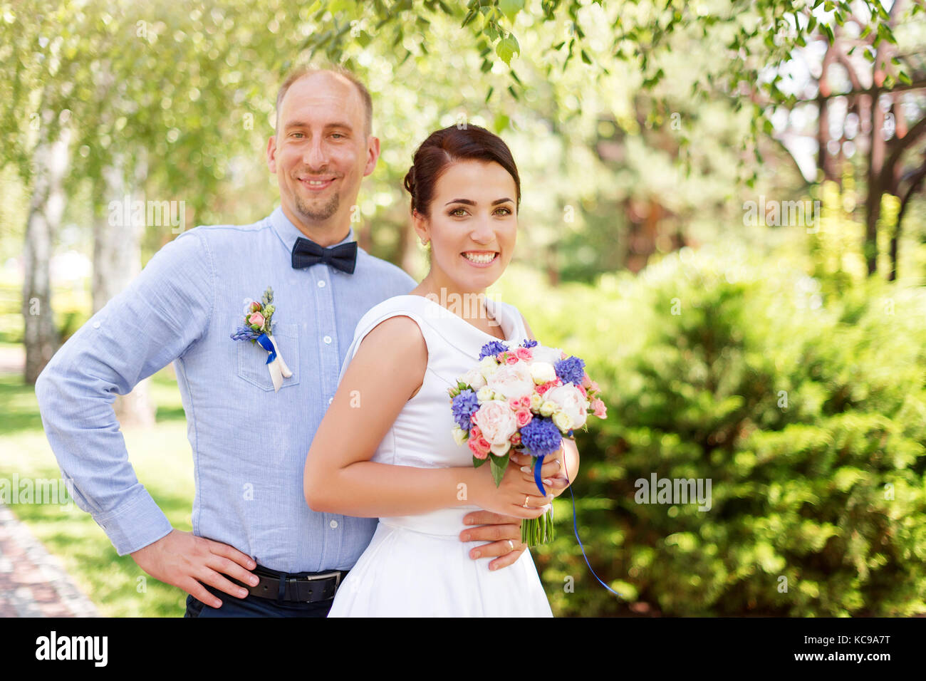Happy just married young wedding couple having fun in the park. Bride ...