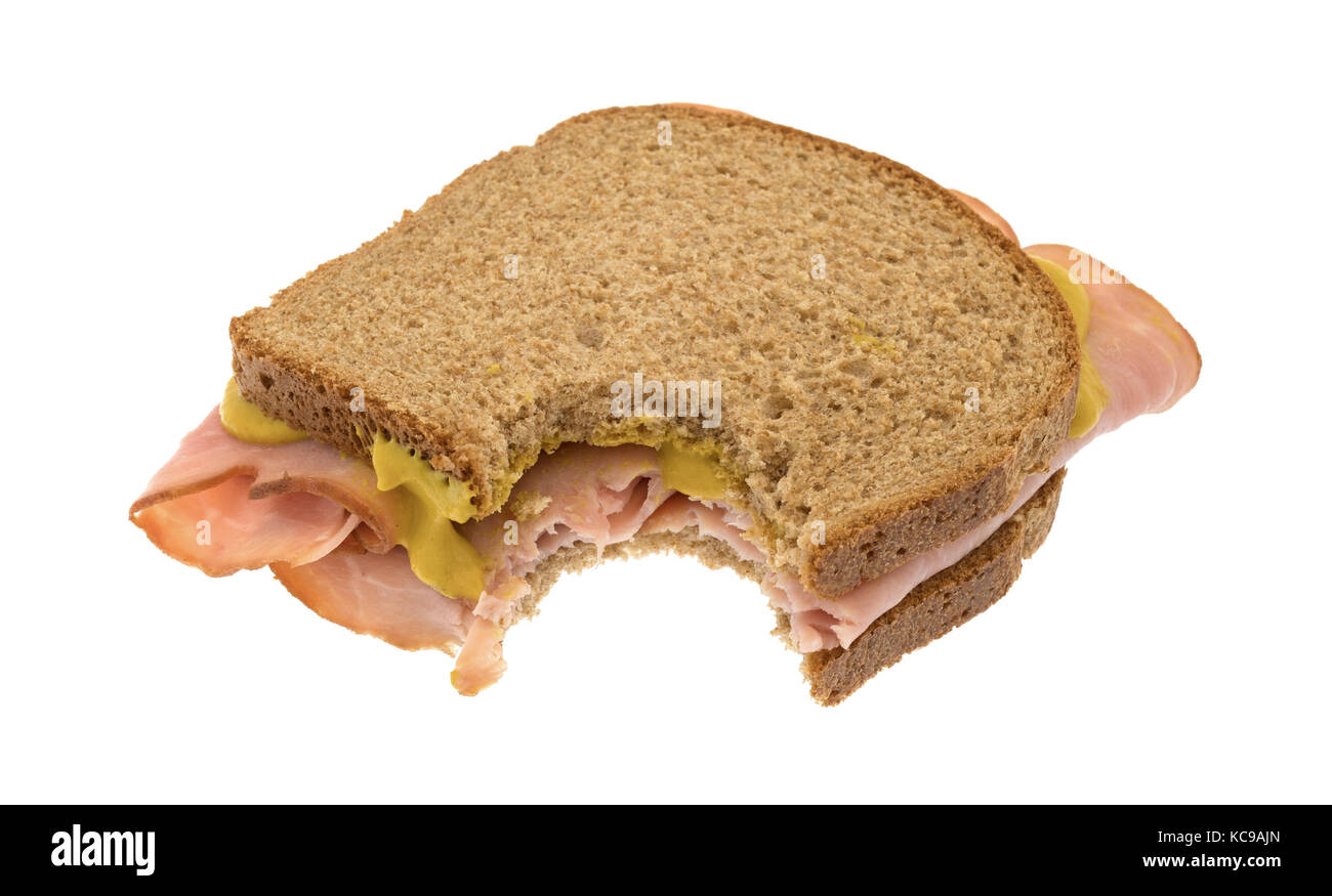 Bitten Virginia ham sandwich on wheat bread with mustard isolated on a ...