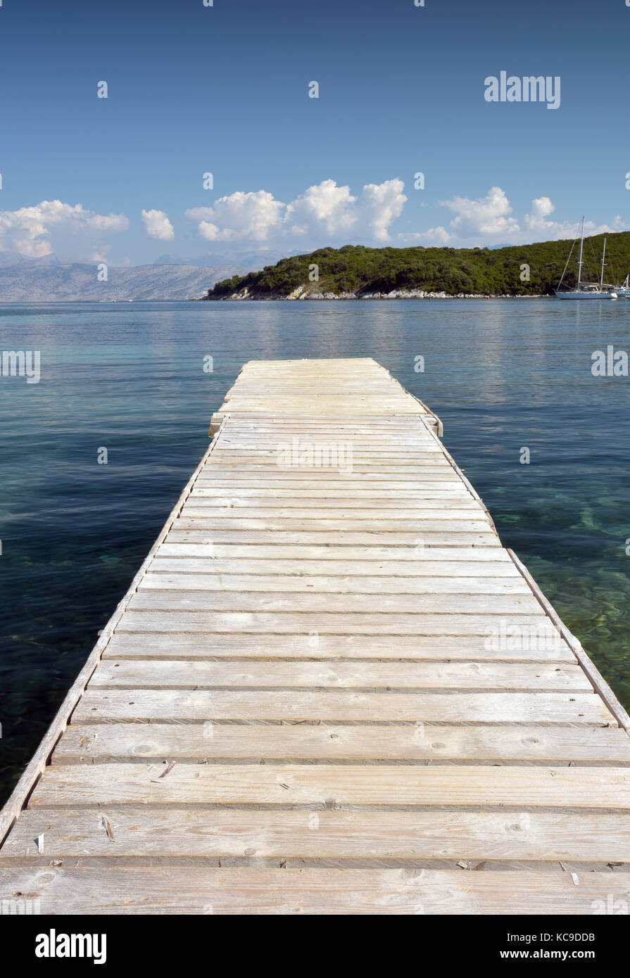 a wooden walkway or boardwalk jetty leading out to sea and tapering to ...