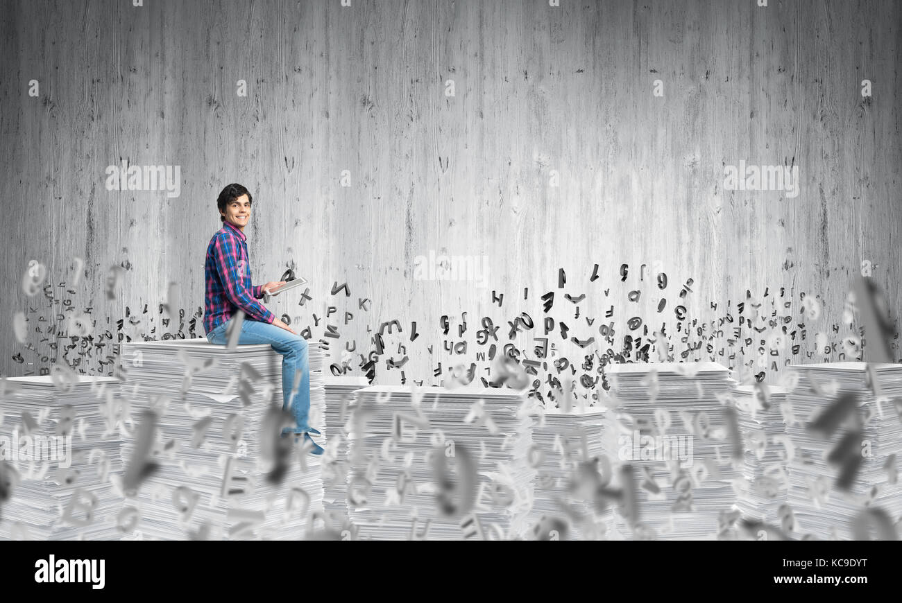 Attractive man sitting on pile of paper documents Stock Photo - Alamy