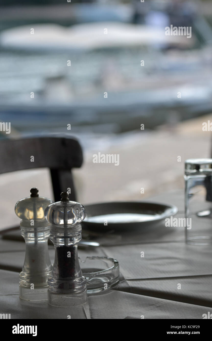 a table set for one at a Greek tavern with salt, pepper and condiments ...