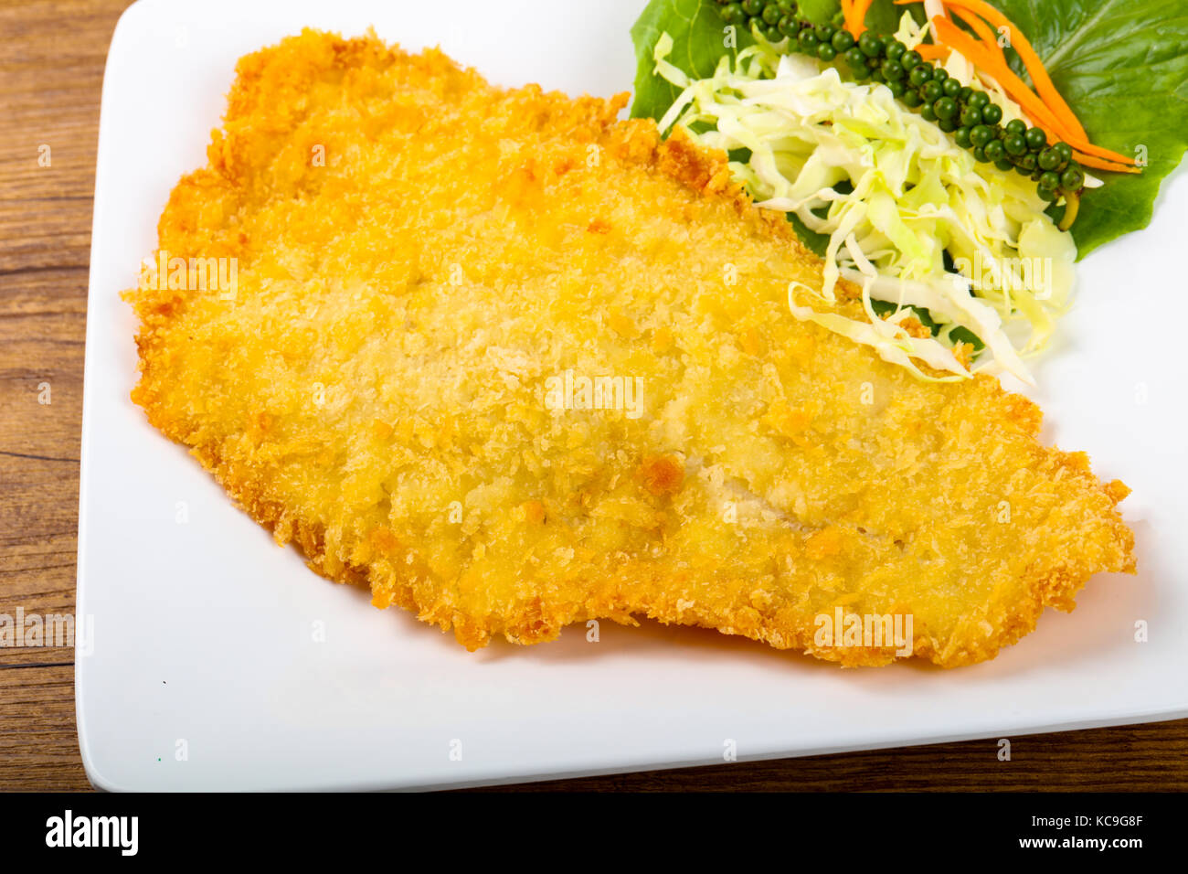 Fried Dory fish with salad on the wood background Stock Photo - Alamy