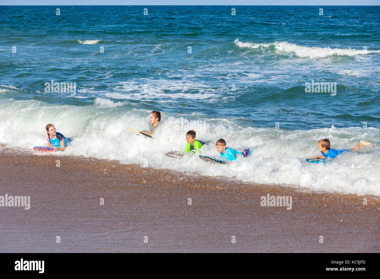 Children playing in the waves hi-res stock photography and images - Alamy