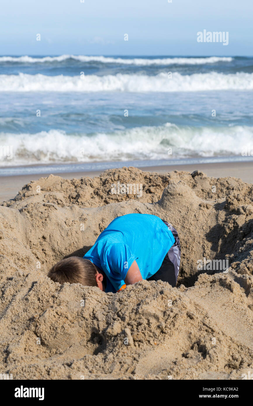 Avon, Outer Banks, North Carolina, USA. Young Boy Digging a Hole in the ...