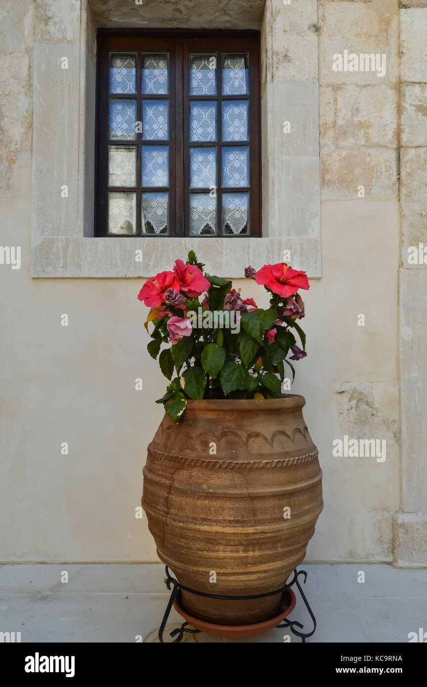 Big amphora and small vase with flowers red on a stony wall Stock Photo ...