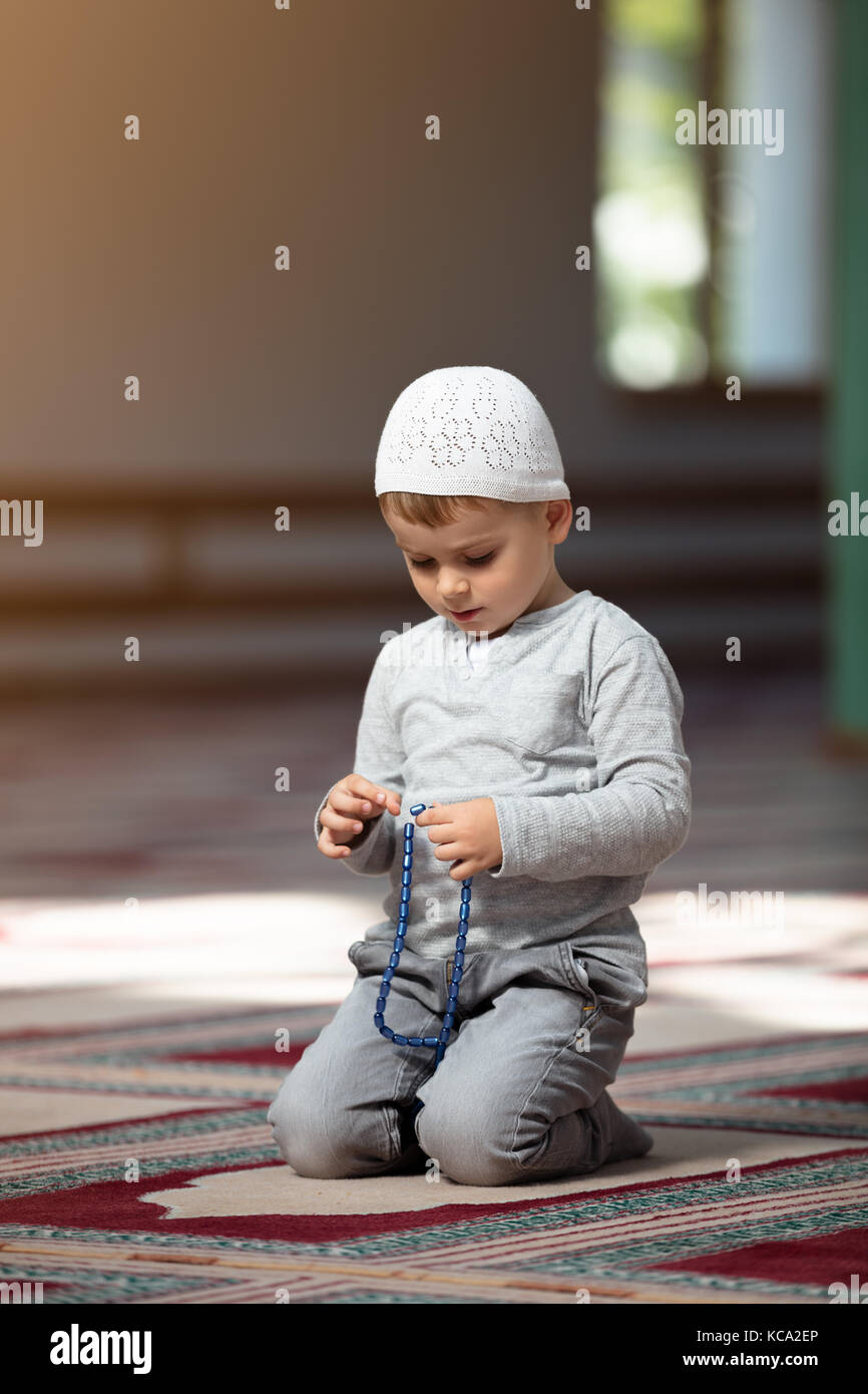The Muslim child prays in the mosque, the little boy prays to God ...