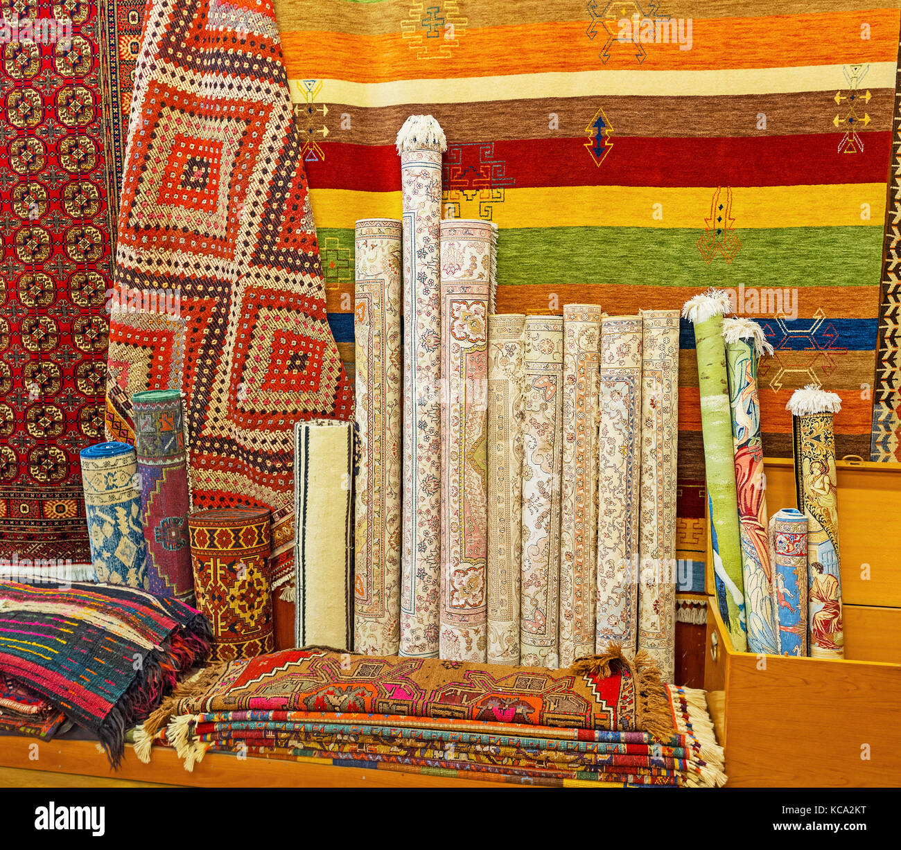 The rolls and stacks of traditional Eastern carpets and kilims in stall ...