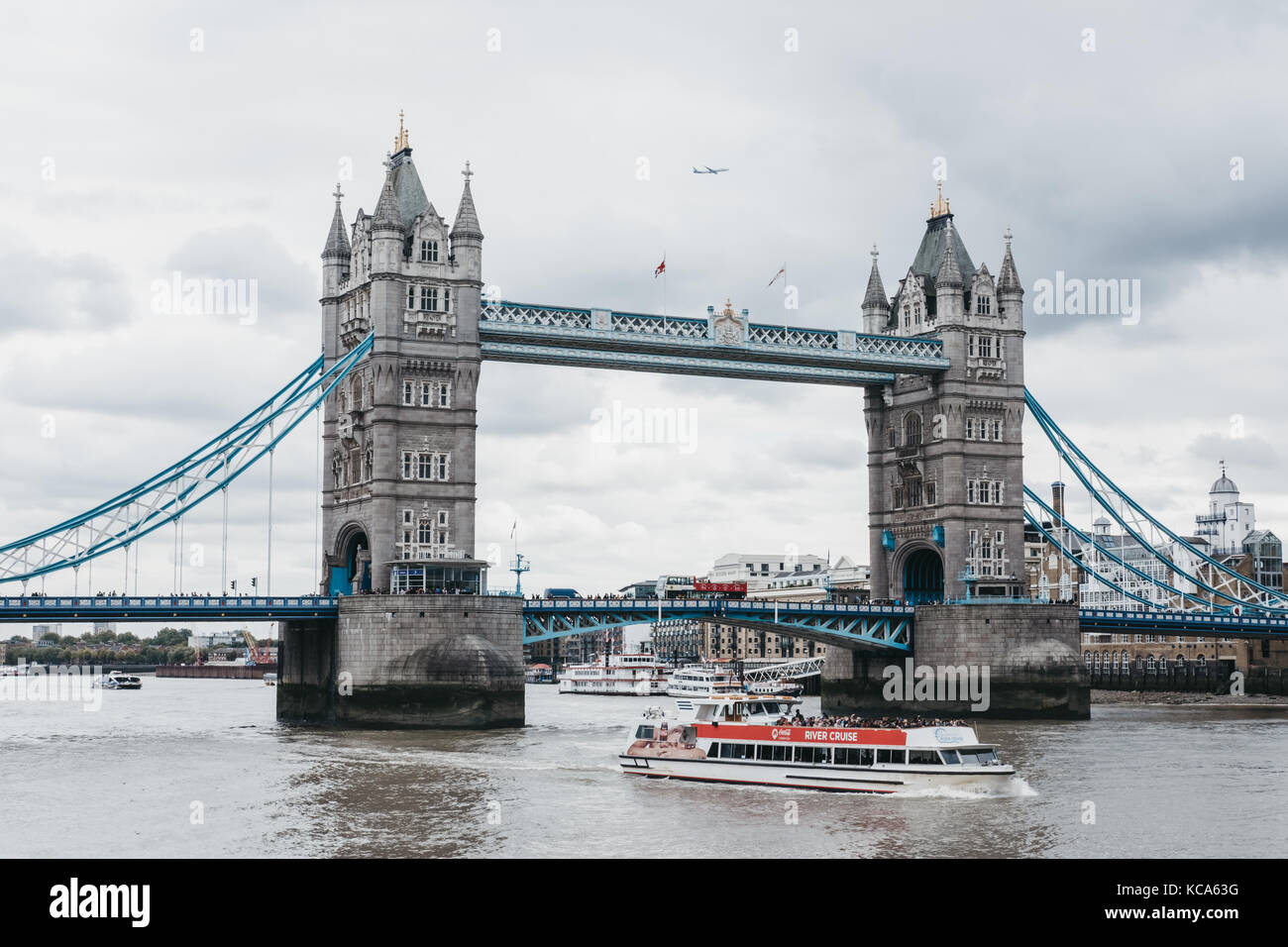 River cruise boat, tour bus and a plane next to Tower Bridge . Tower ...