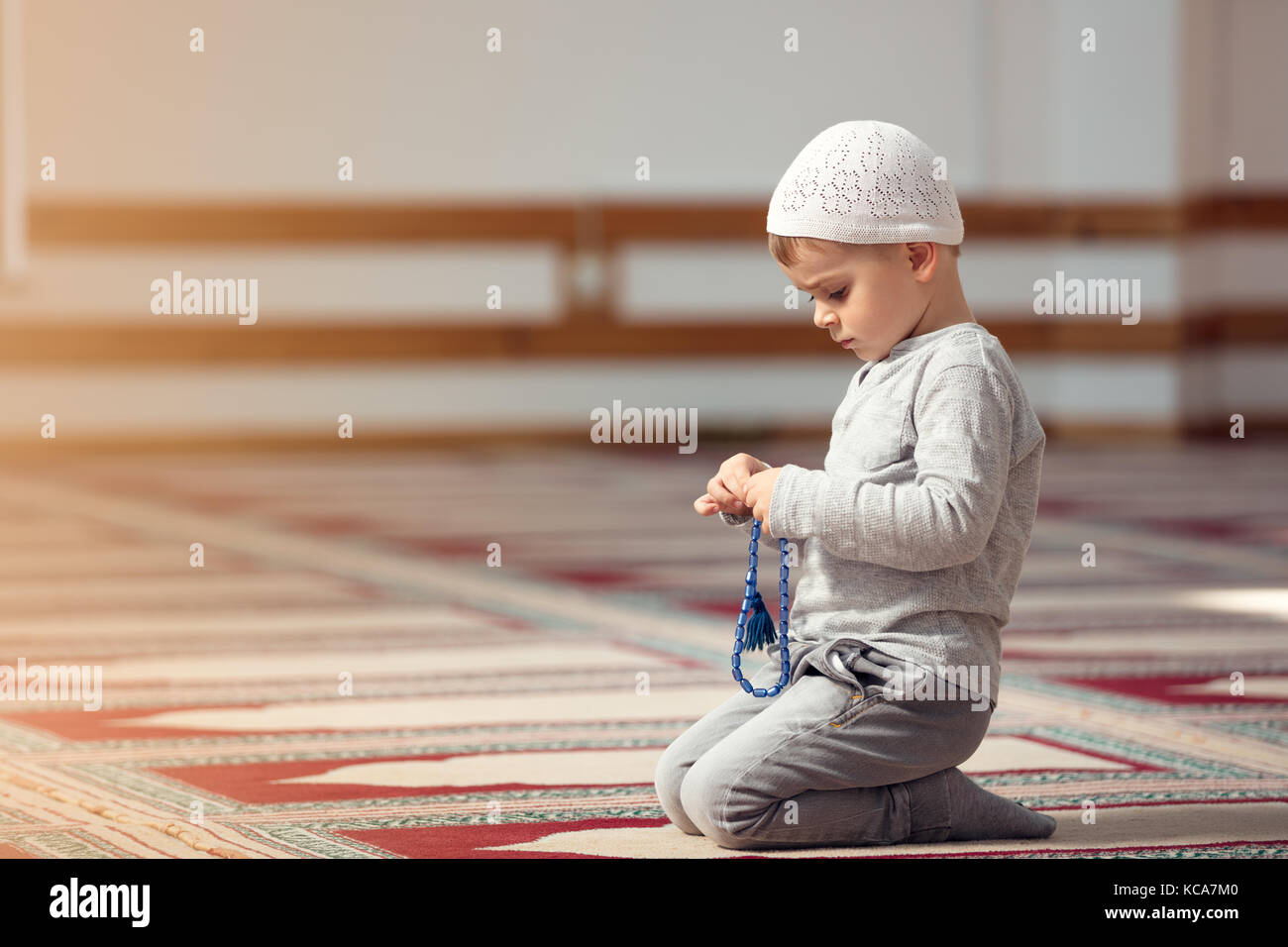 The Muslim child prays in the mosque, the little boy prays to God ...