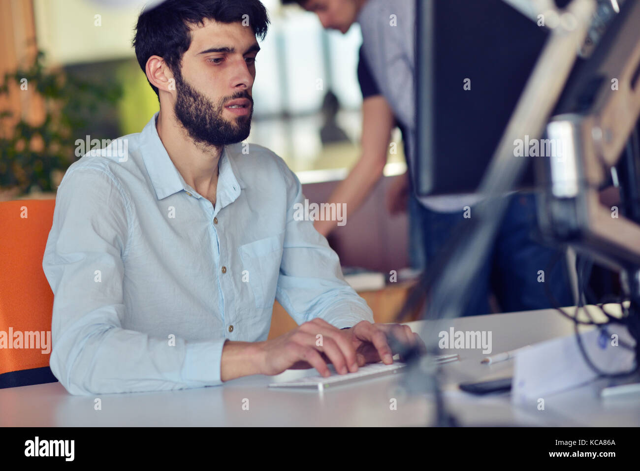 young business man working on desktop computer at his desk in modern ...