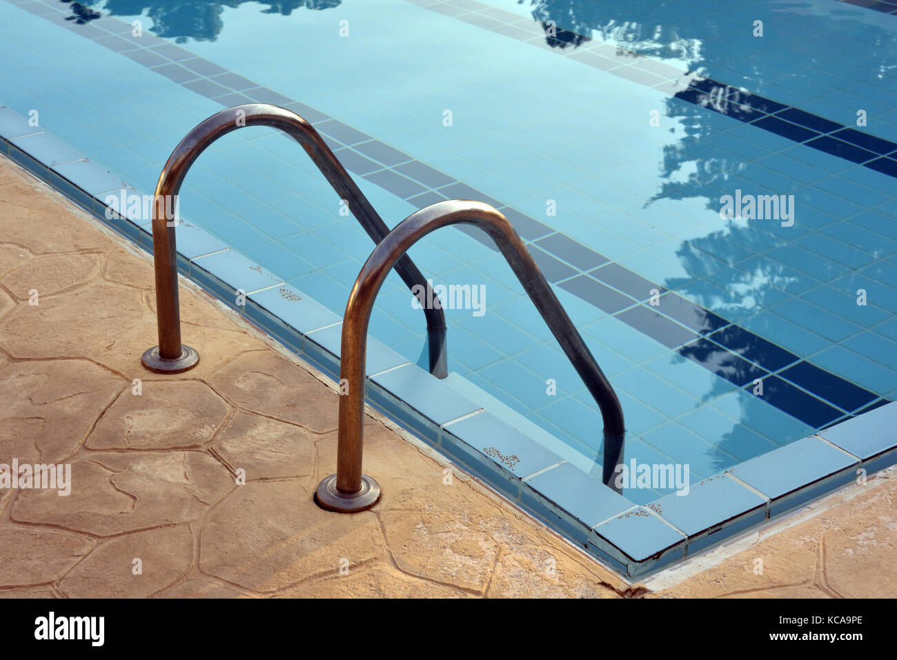 a handrail and steps into a swimming pool in a luxury pool at a hitel ...