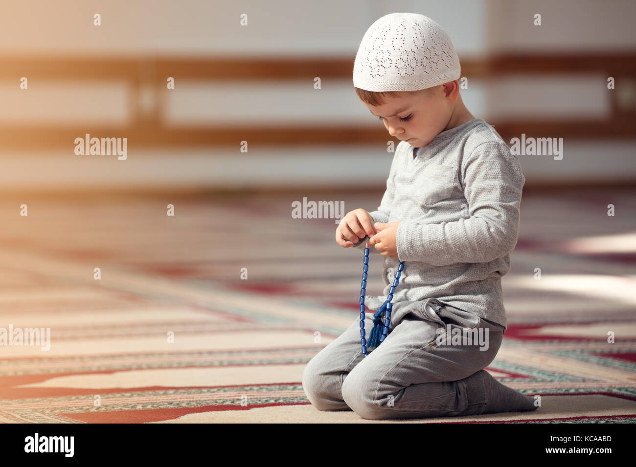 The Muslim child prays in the mosque, the little boy prays to God ...