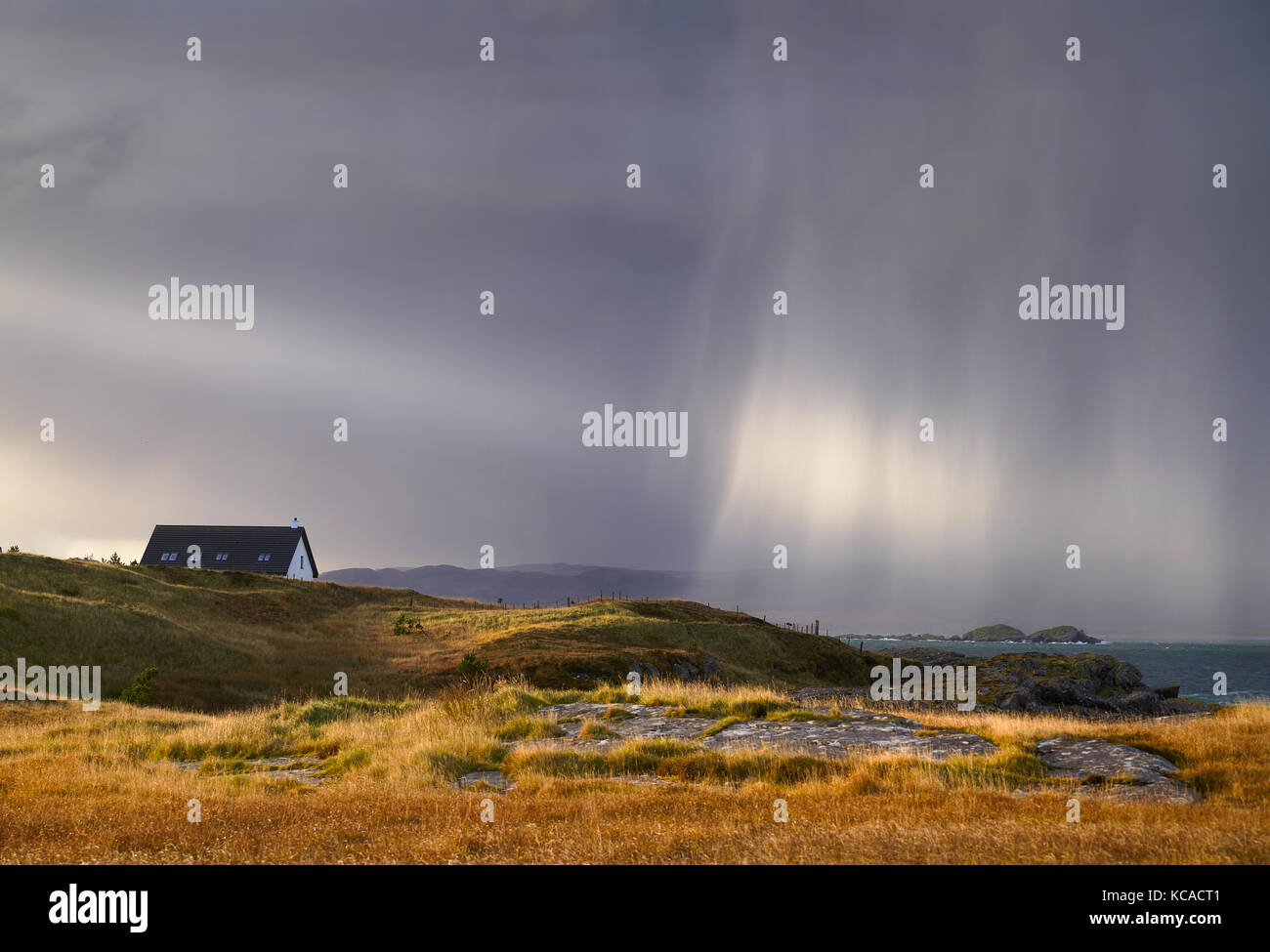 A heavy rain shower over a croft at Loch Ewe, Scottish Highlands ...