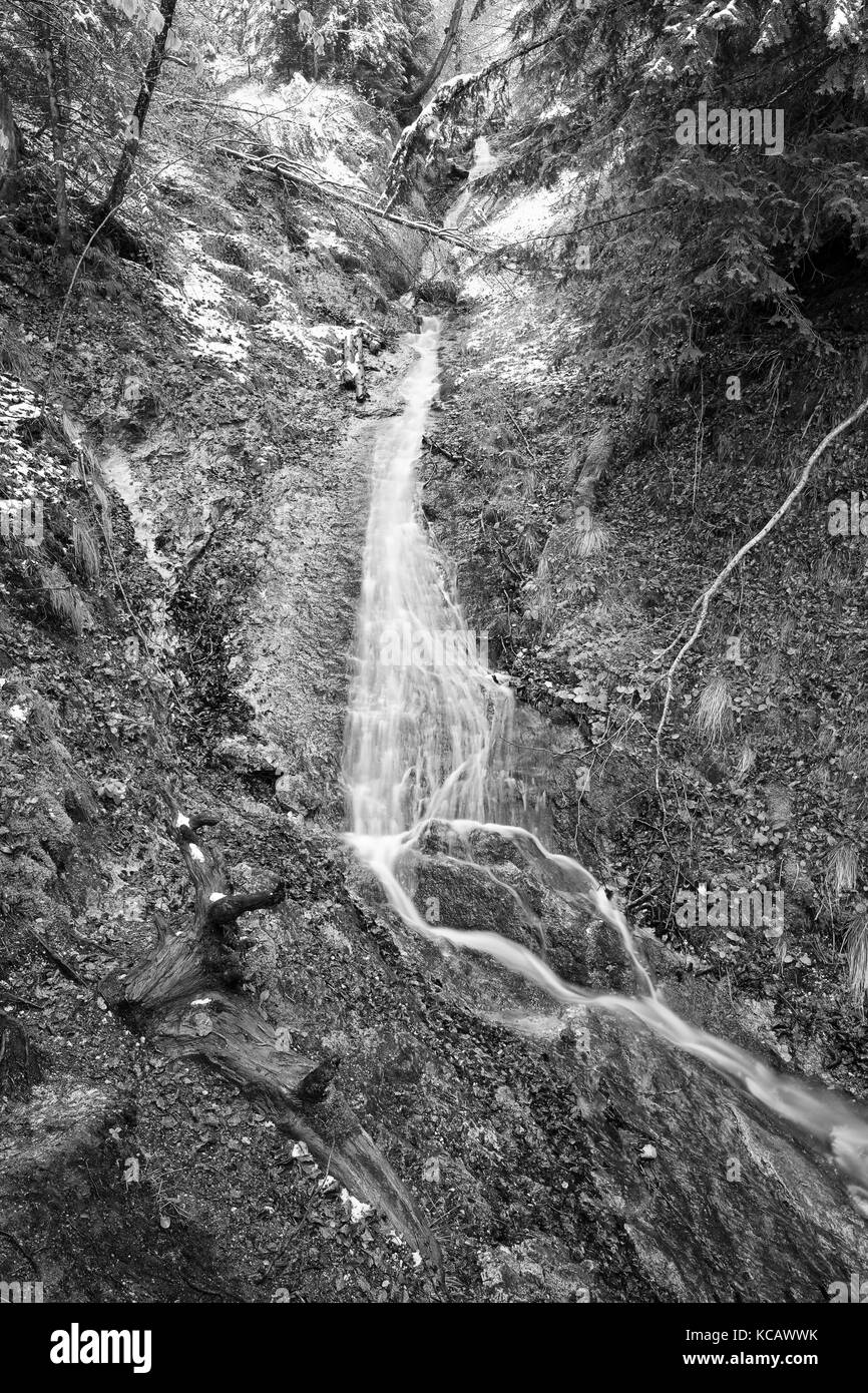 Water spray below small waterfall on mountain stream, water is falling ...