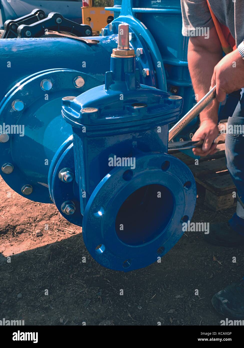 Worker hands screwing Gate valve with nuts on new dring water piping ...