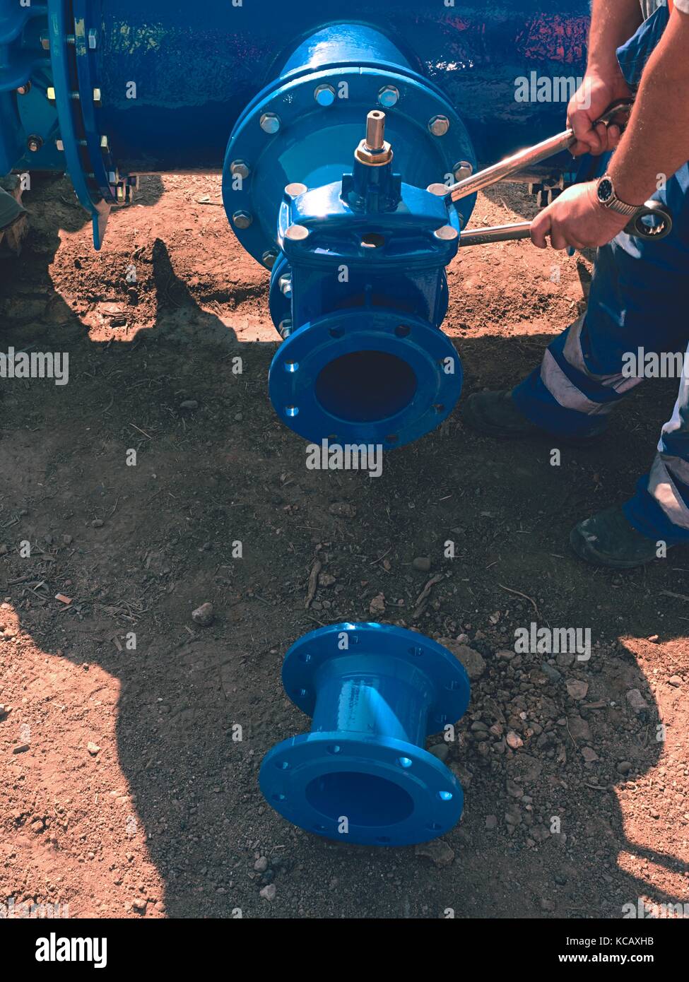 Worker hands screwing Gate valve with nuts on new dring water piping ...