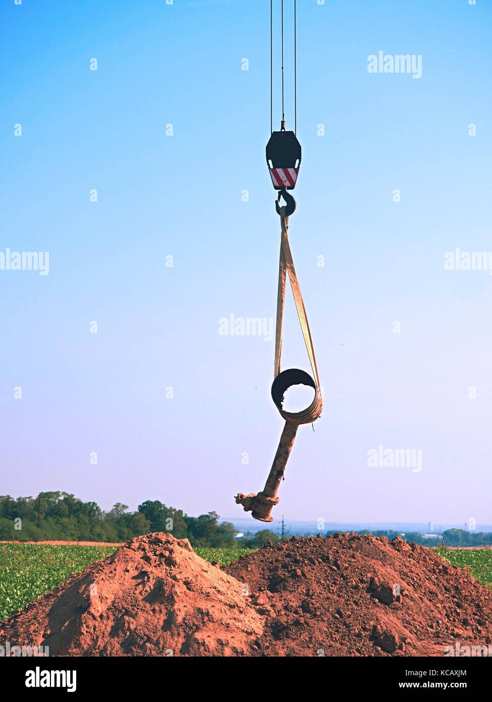 Hanging old tube on crane rope. Clear blue sky in background Stock ...