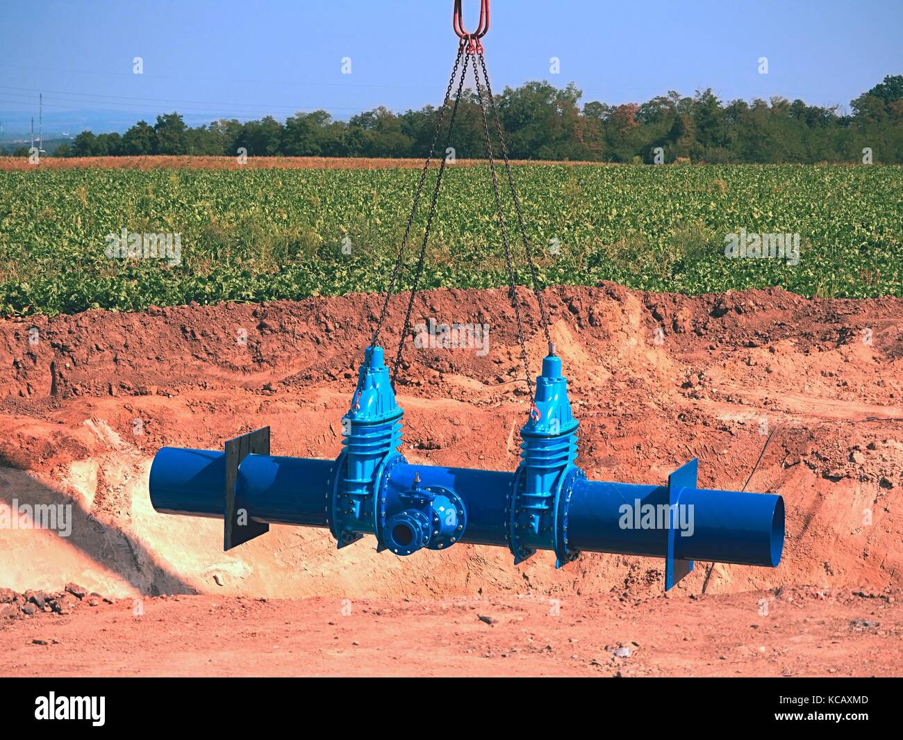 Crane handling 500mm pipe with gate valves. Construction process to ...