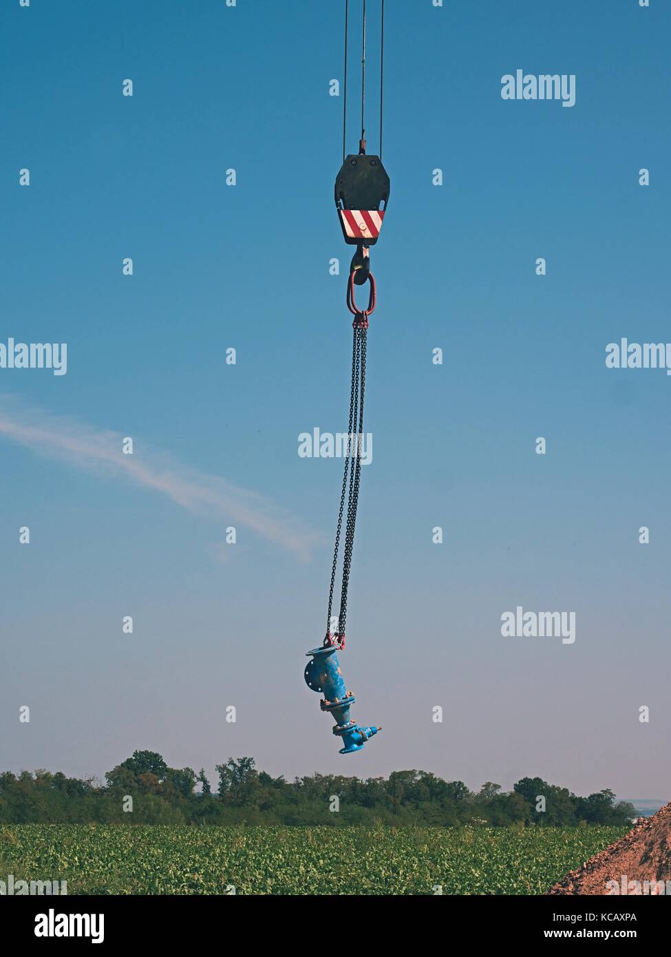 Crane lifting tube and gate valve within water pipeline building. New ...