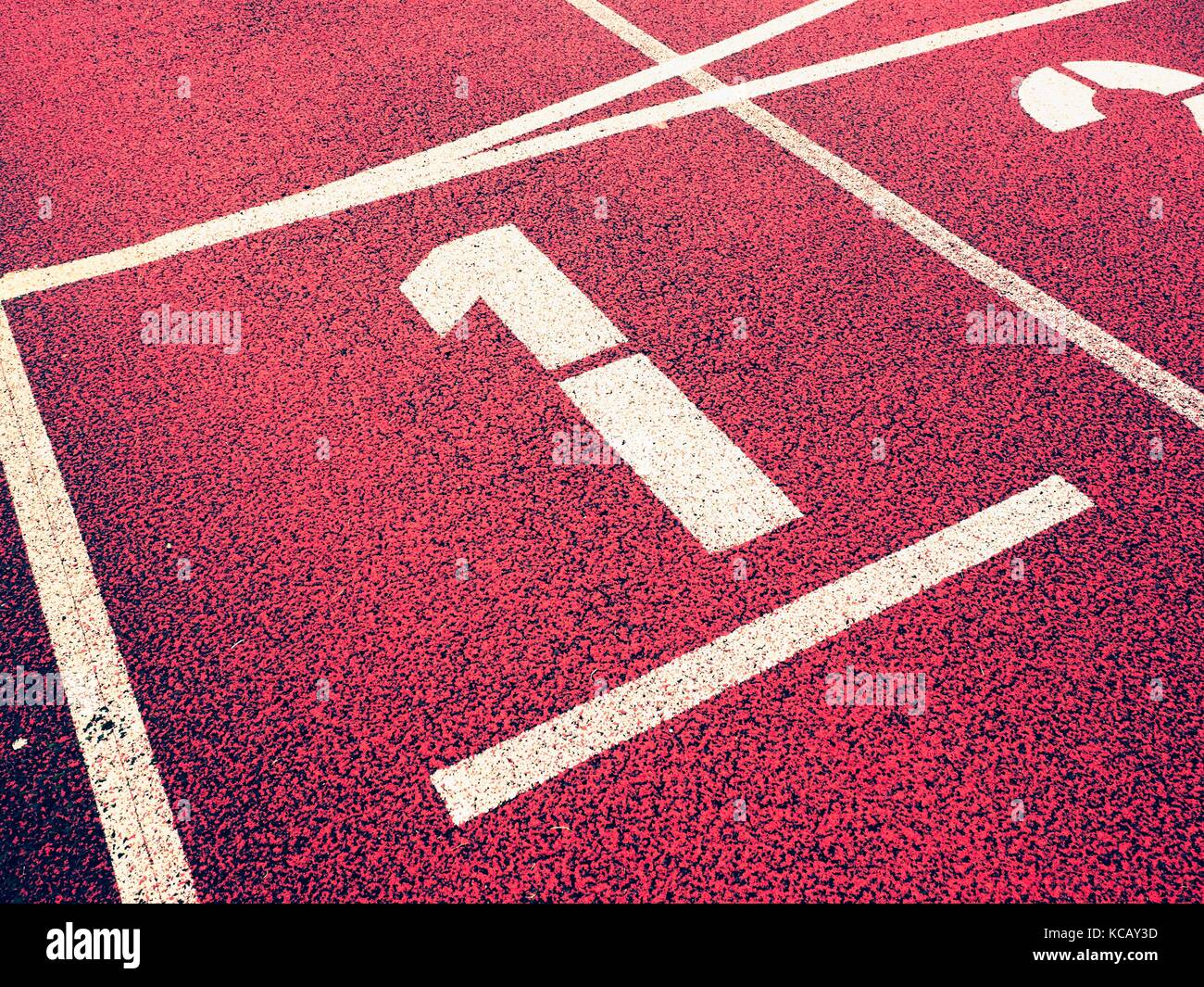 Number one. White athletic track number on red rubber racetrack ...