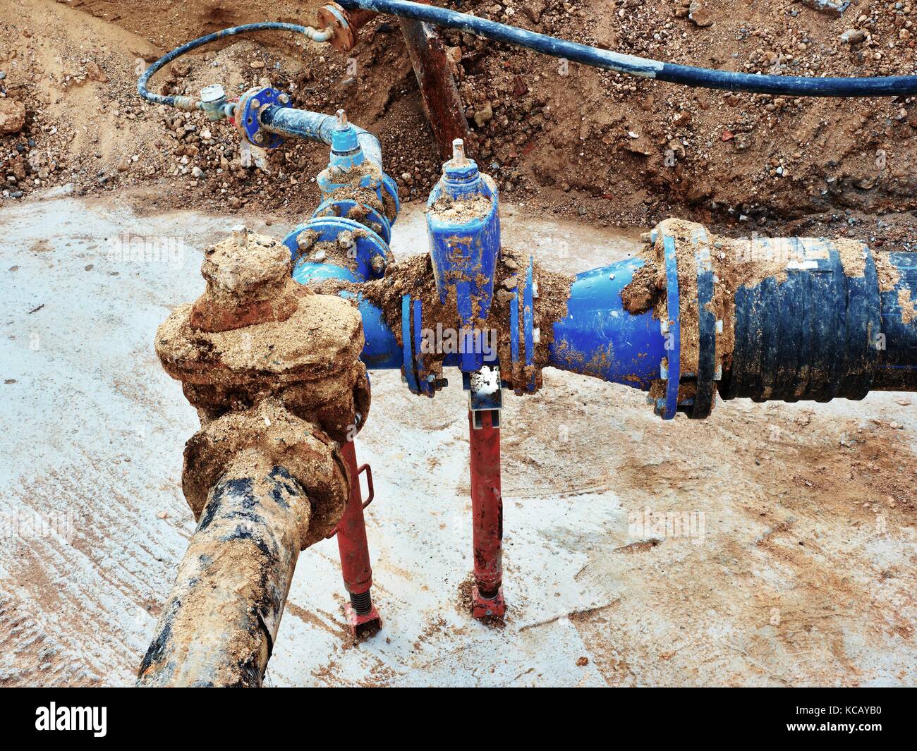 Old big drink water pipes joined with new blue gate valves and ...