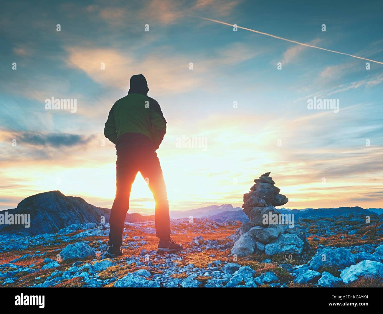 Stones pyramid on Alpine gravel mountain summit. Daybreak horizon above ...