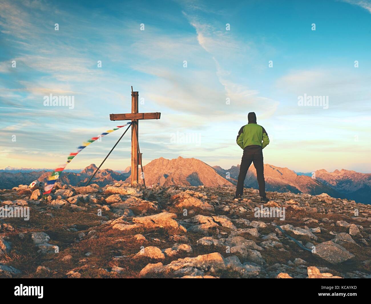 Tourist stand on rocky view point and watching into misty Alpine valley ...