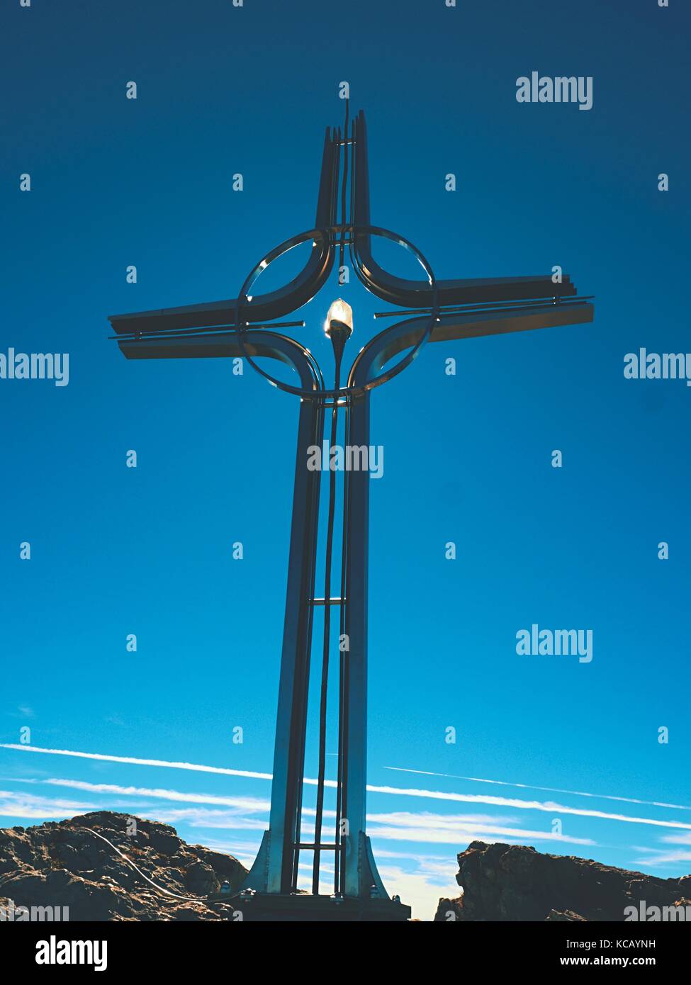 Praying summit cross on high rocky mountain. Steel artistic crucifix on ...
