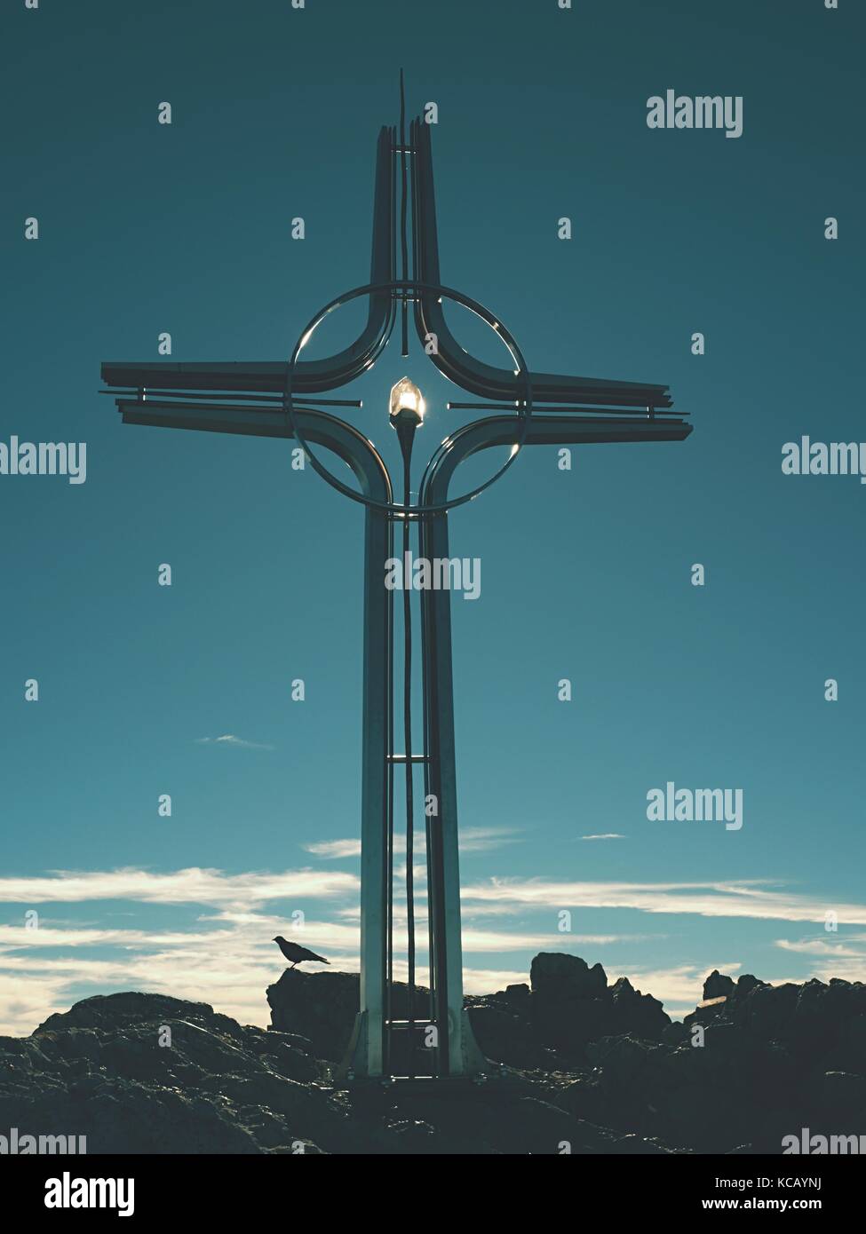 Praying summit cross on high rocky mountain. Steel artistic crucifix on ...