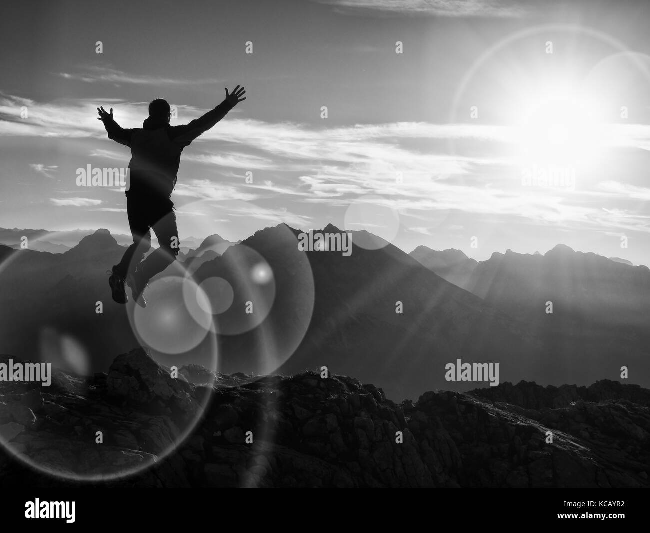 Lens flare effect. Bow light circles. Crazy hiker jumping at peak of ...