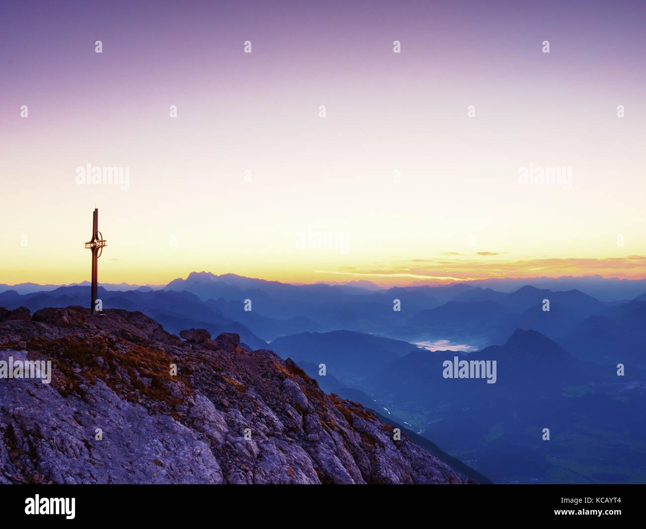 Steel crucifix at mountain peak in Alps. Sharp rocky summit, daybreak ...