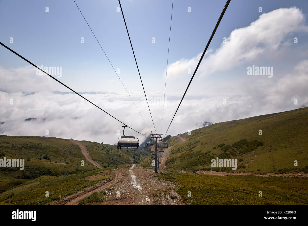 View from top of ropeway with multiple seats and stretched cables above ...