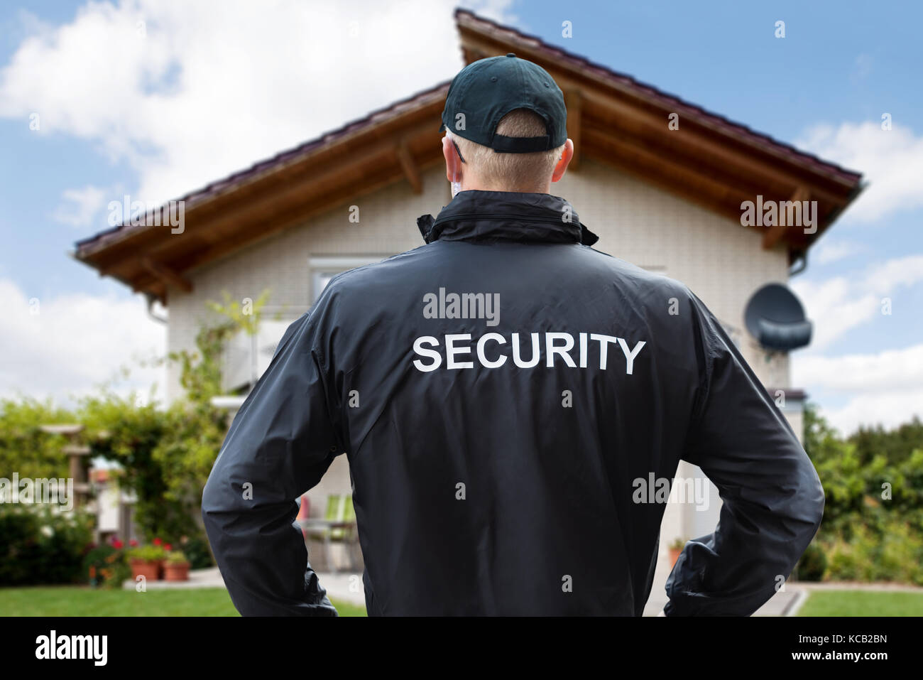 Rear View Of A Male Security Guard Standing Outside The House Stock ...