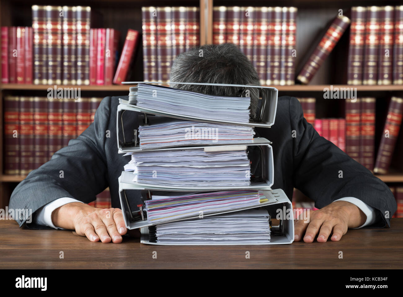 A Male Lawyer Leaning On Stacked Folders On Wooden Desk In Courtroom ...