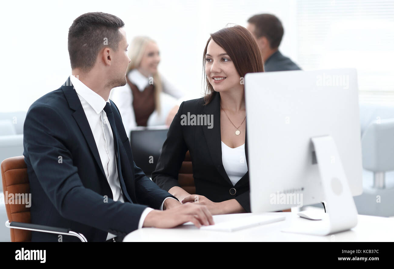 employees sitting behind a Desk in the office Stock Photo - Alamy