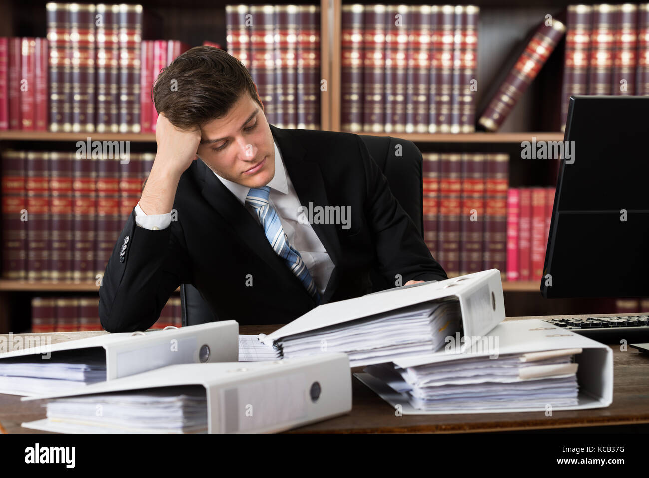 Stressed Young Male Accountant Looking At Heap Of Binders At Desk Stock ...