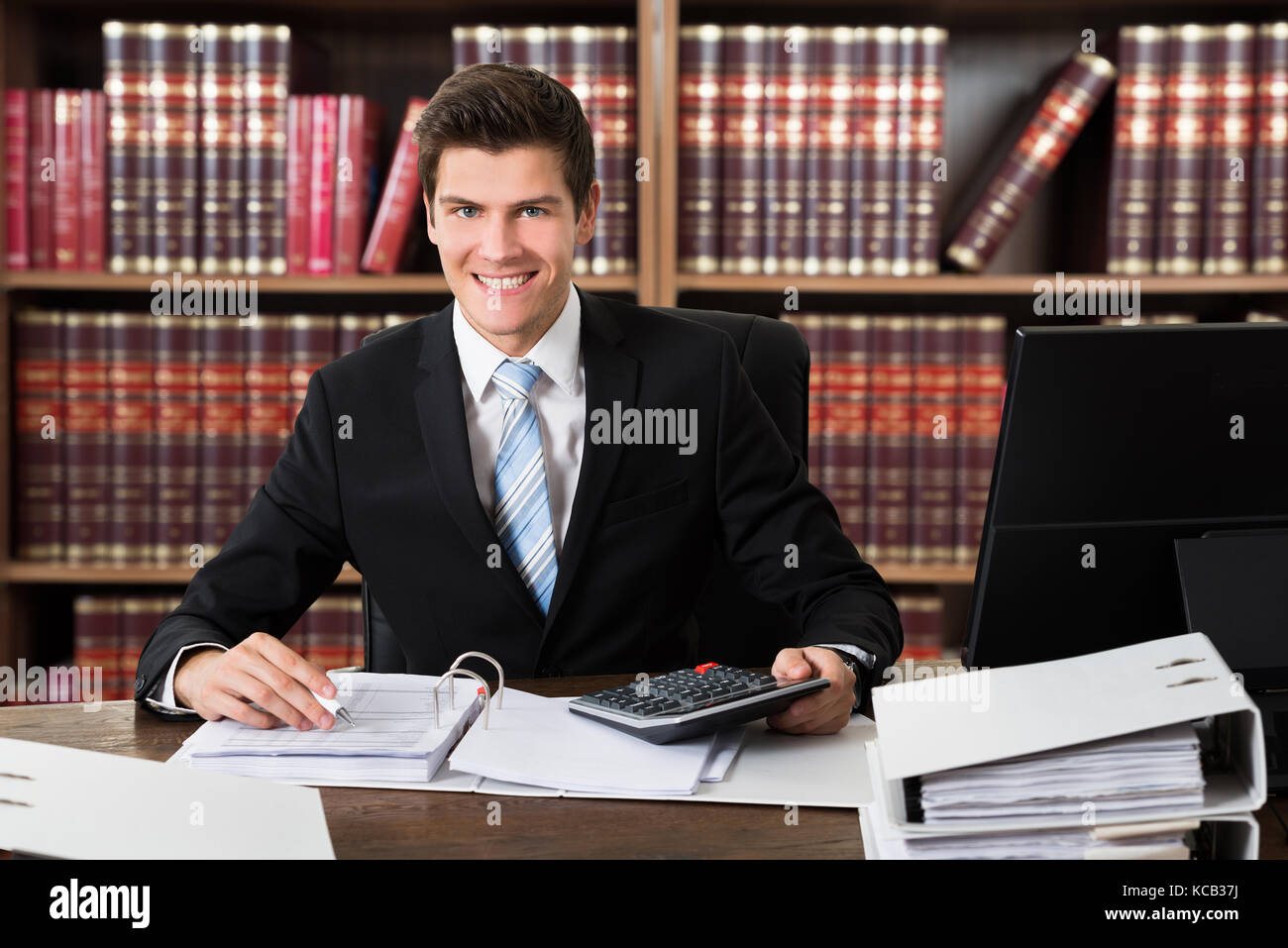 Portrait Of A Successful Male Accountant Calculating Invoice Using ...