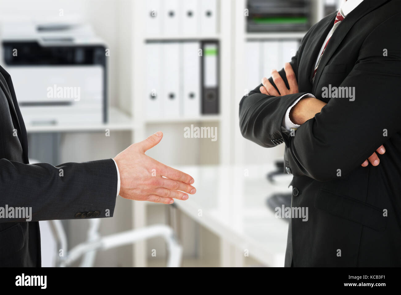 Person Offering Handshake To Businessman With Arm Crossed At Office ...