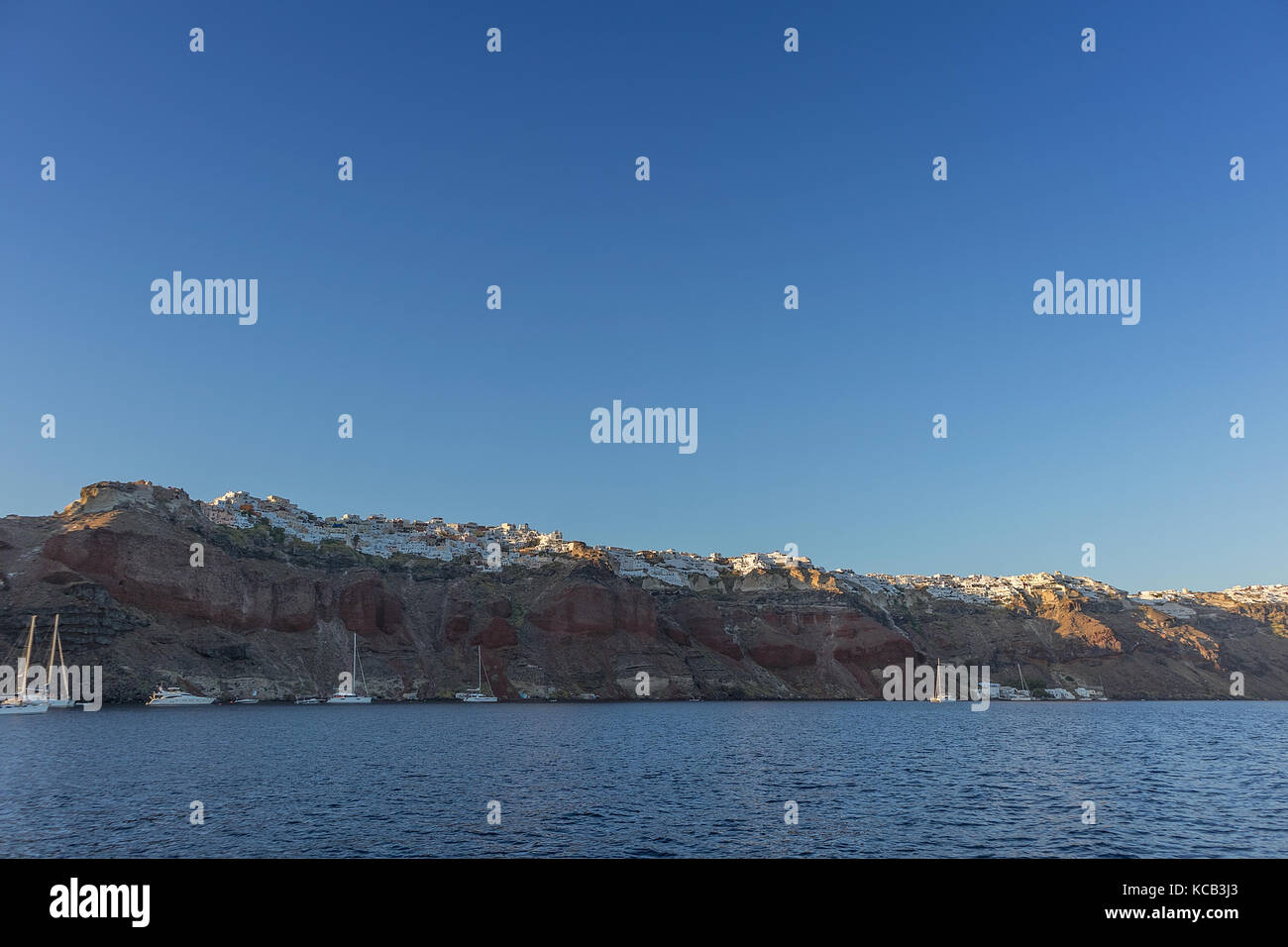 sunset seen from the sea of oia town with sailboat Stock Photo - Alamy