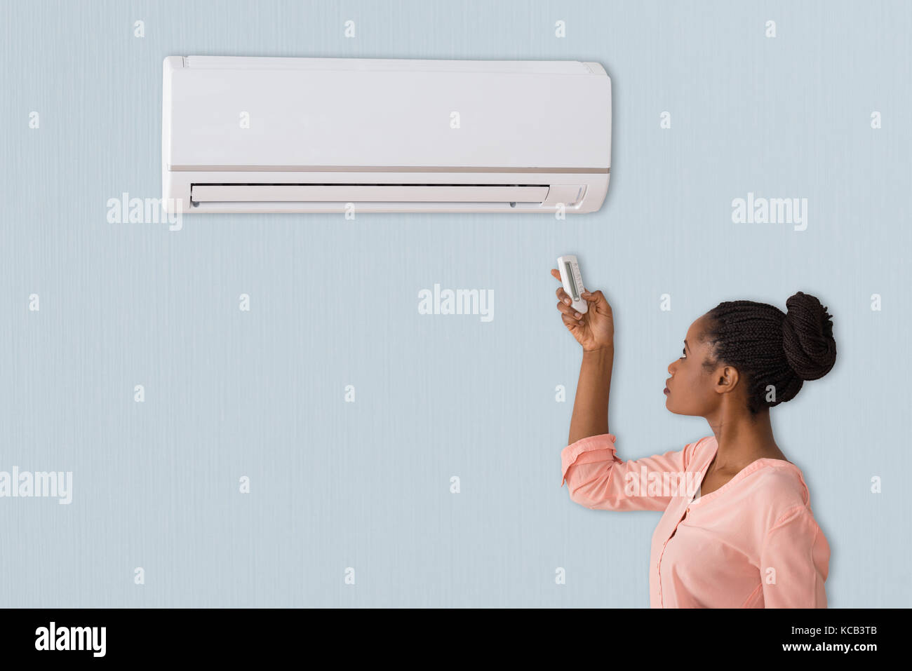 An African Young Woman Using Air Conditioner At Home Stock Photo - Alamy