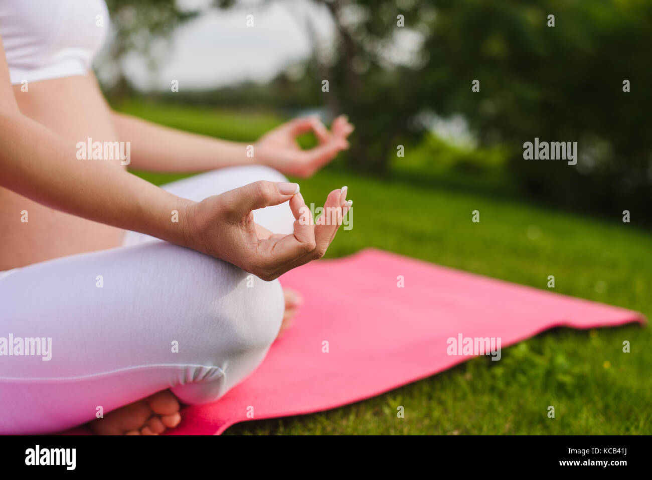 Close up of female hand zen gesturing. Woman sits in lotus position ...