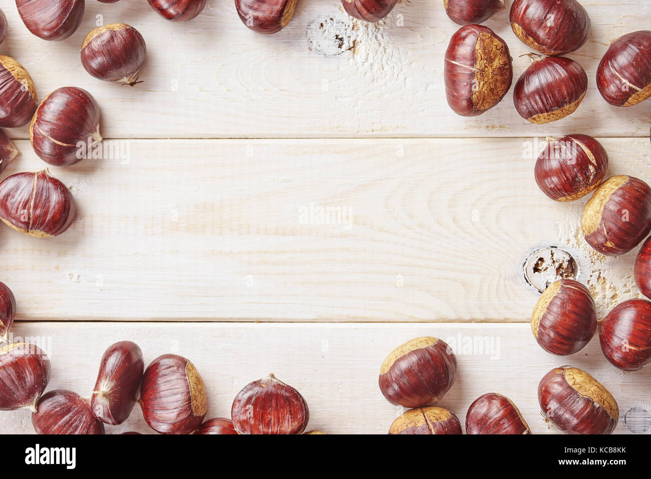Top view of chestnuts on wooden desk forming round frame for copy space ...