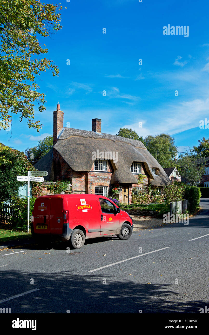 Royal Mail van parked in front of thatched cottage in the village of ...