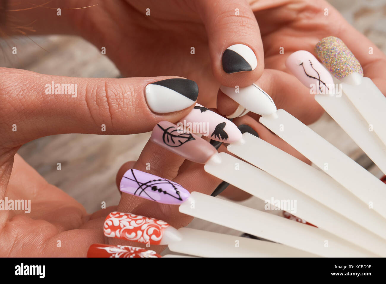 Manicured hands holding color nail samples Stock Photo - Alamy