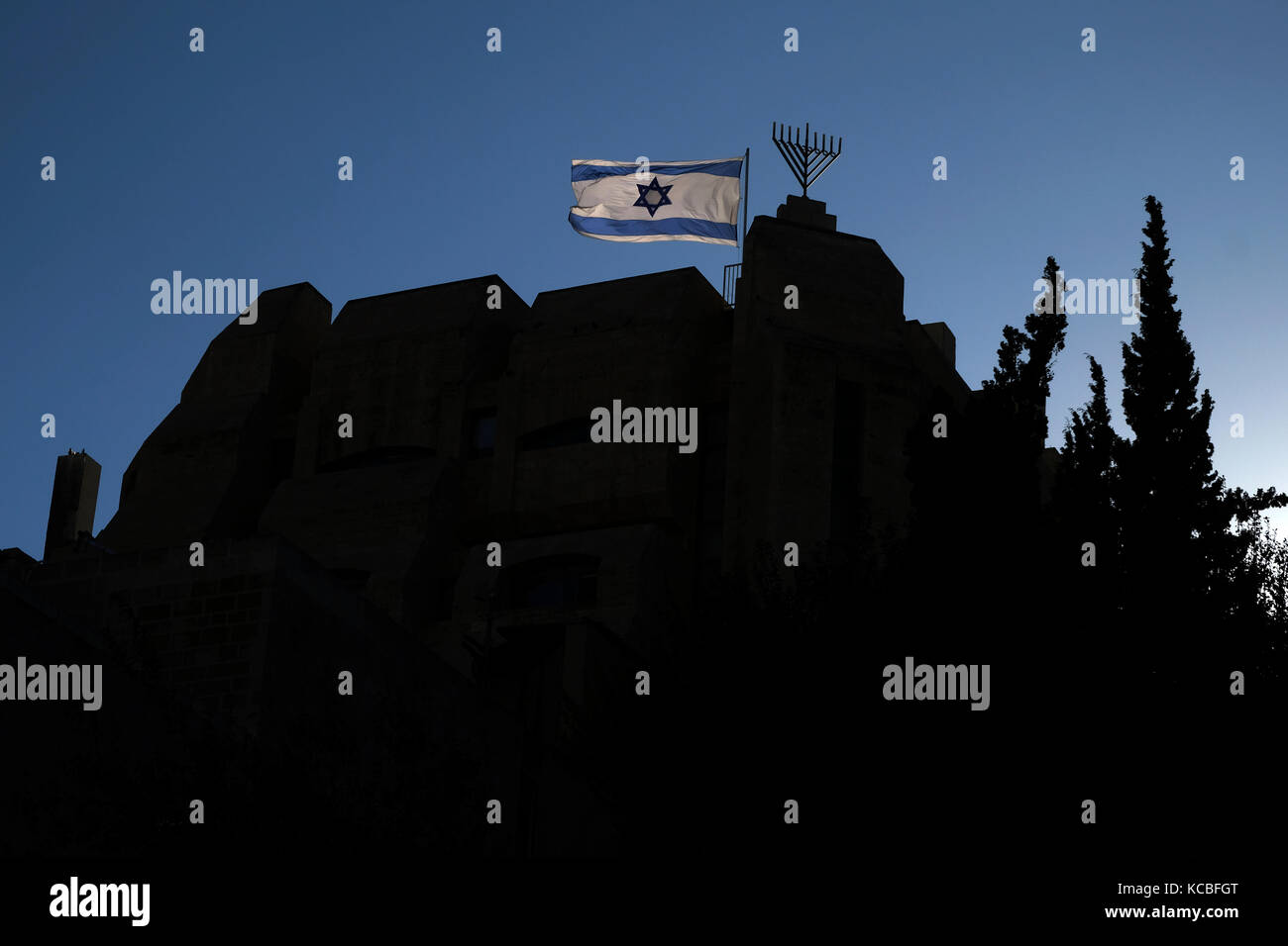 A silhouetted of the Israeli flag fluttering over the Yeshivat Hakotel ...